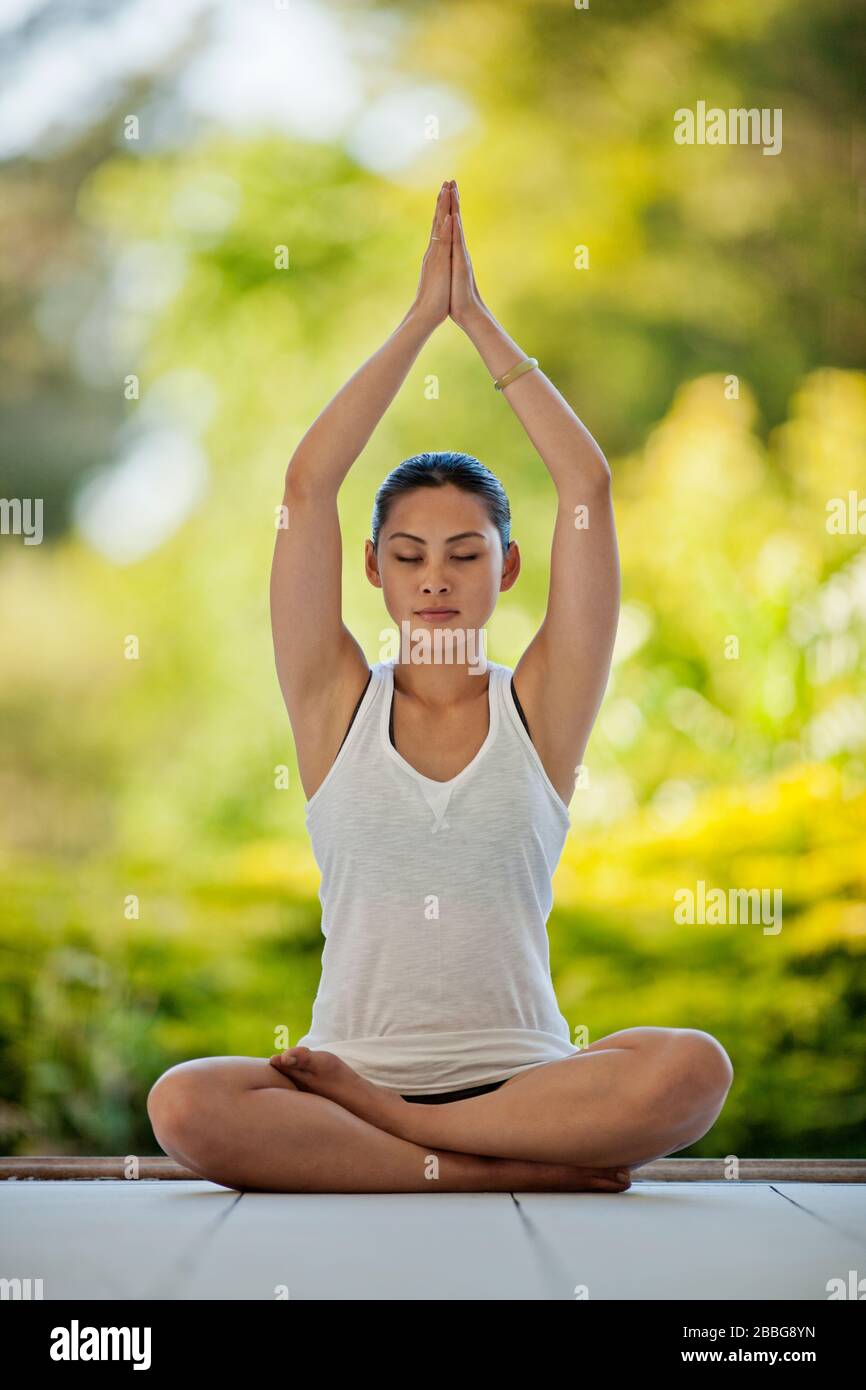 Mid adult woman practicing yoga on a deck Stock Photo - Alamy