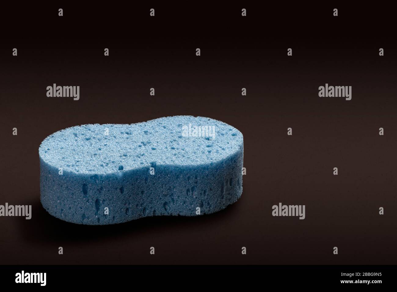 Dry blue bath sponge on a brown gradient background Stock Photo - Alamy