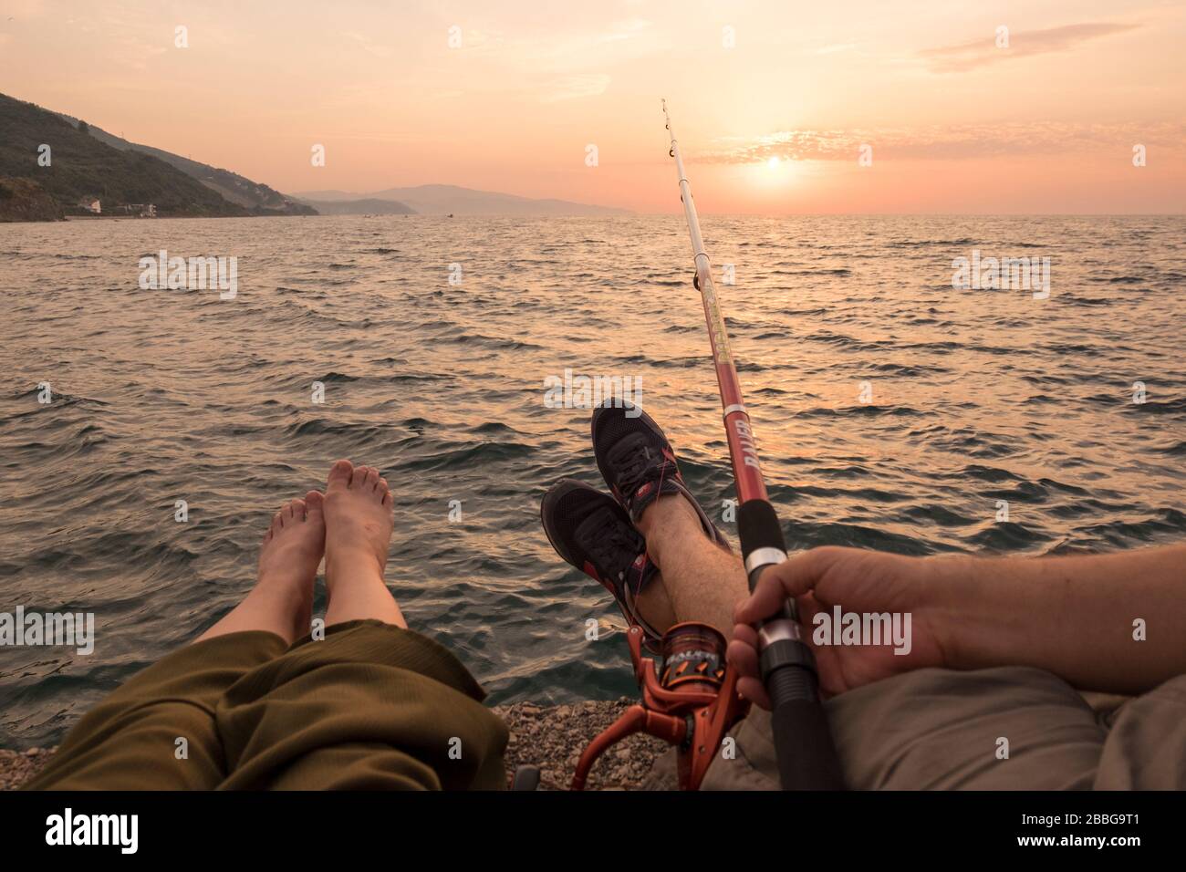 Sunset silhouette of holding fish Stock Photo - Alamy