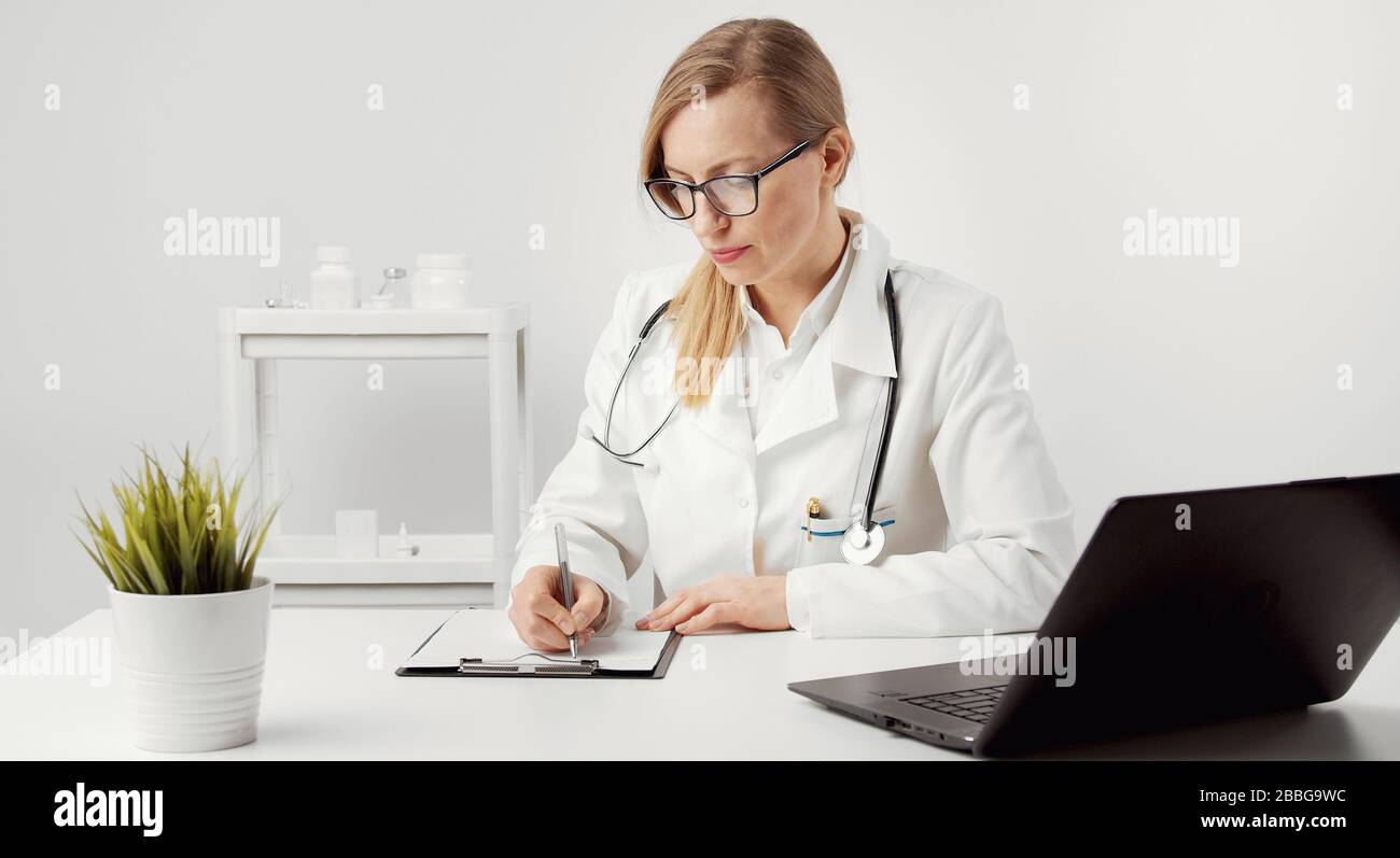 Female doctor filling hospital chart Stock Photo - Alamy