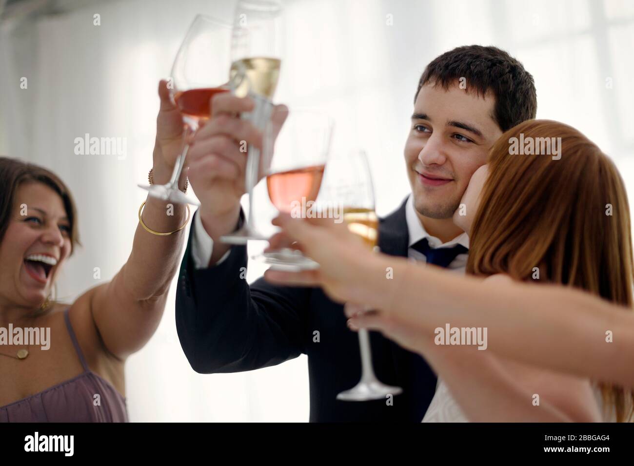 A happy bride and groom celebrating with a friend at their wedding ...