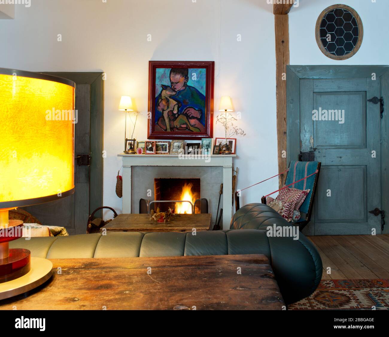 living room with open fire place, leather sofa, green doors, chest and ...