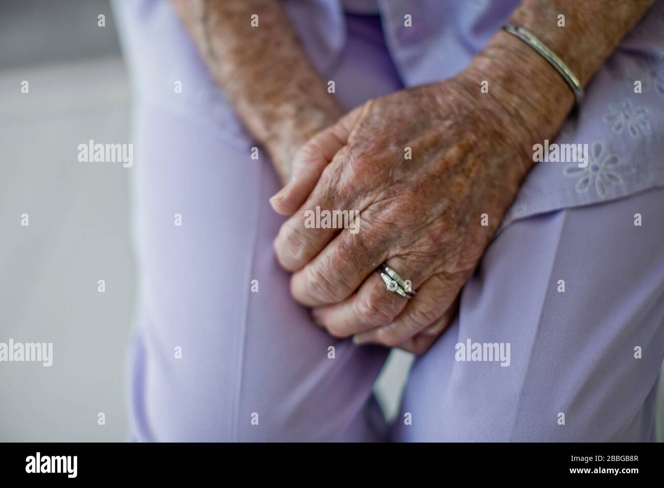 Hands of an elderly woman clasped in her lap Stock Photo - Alamy