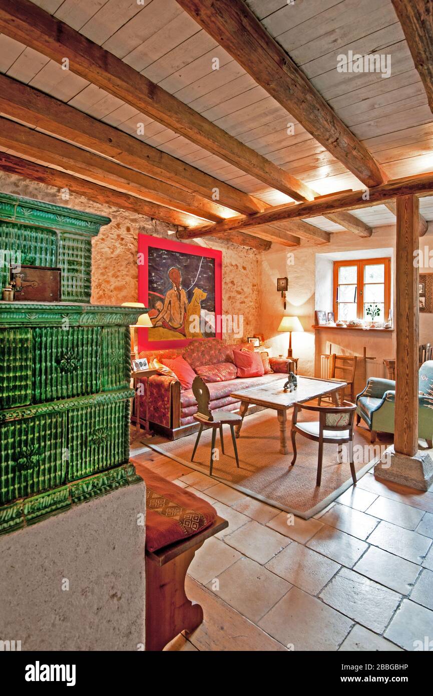 living room in country style with green tiled stove, sofa, wooden ...