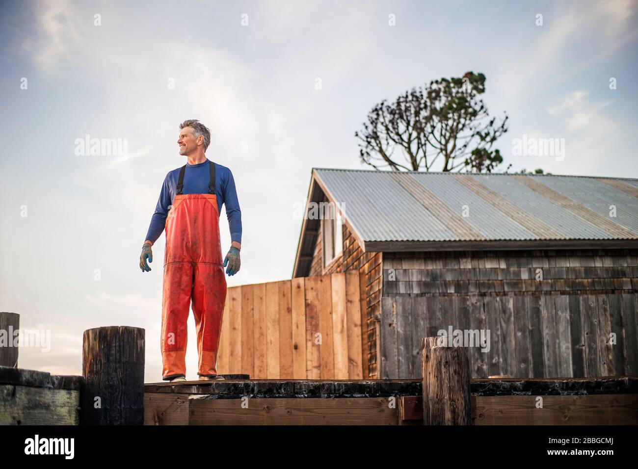 Mid adult man standing on a dock Stock Photo - Alamy