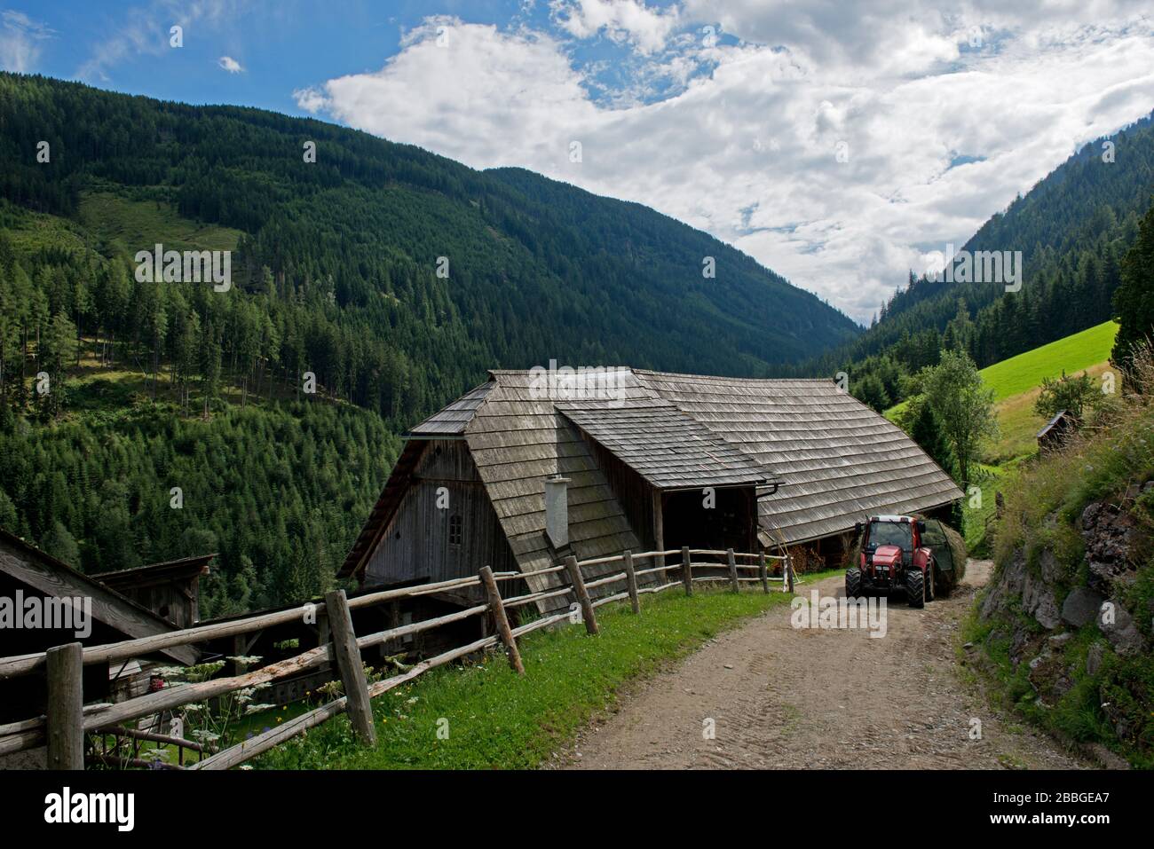 historical Austrian farmhouse on steep slope in mountain valley ...