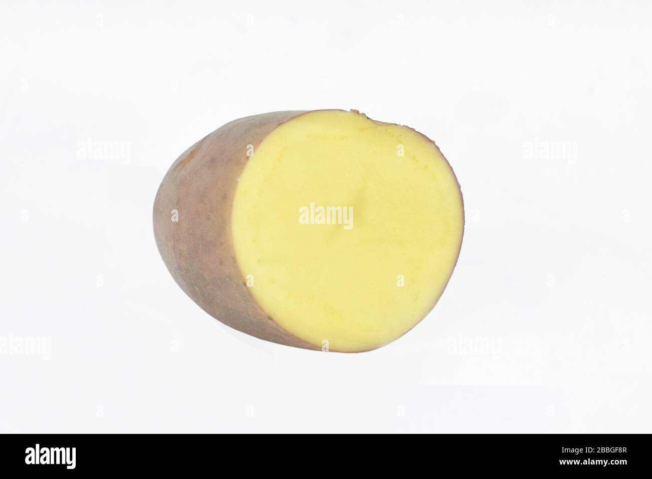 Side view of a big brown potato sliced in half before an isolated white ...