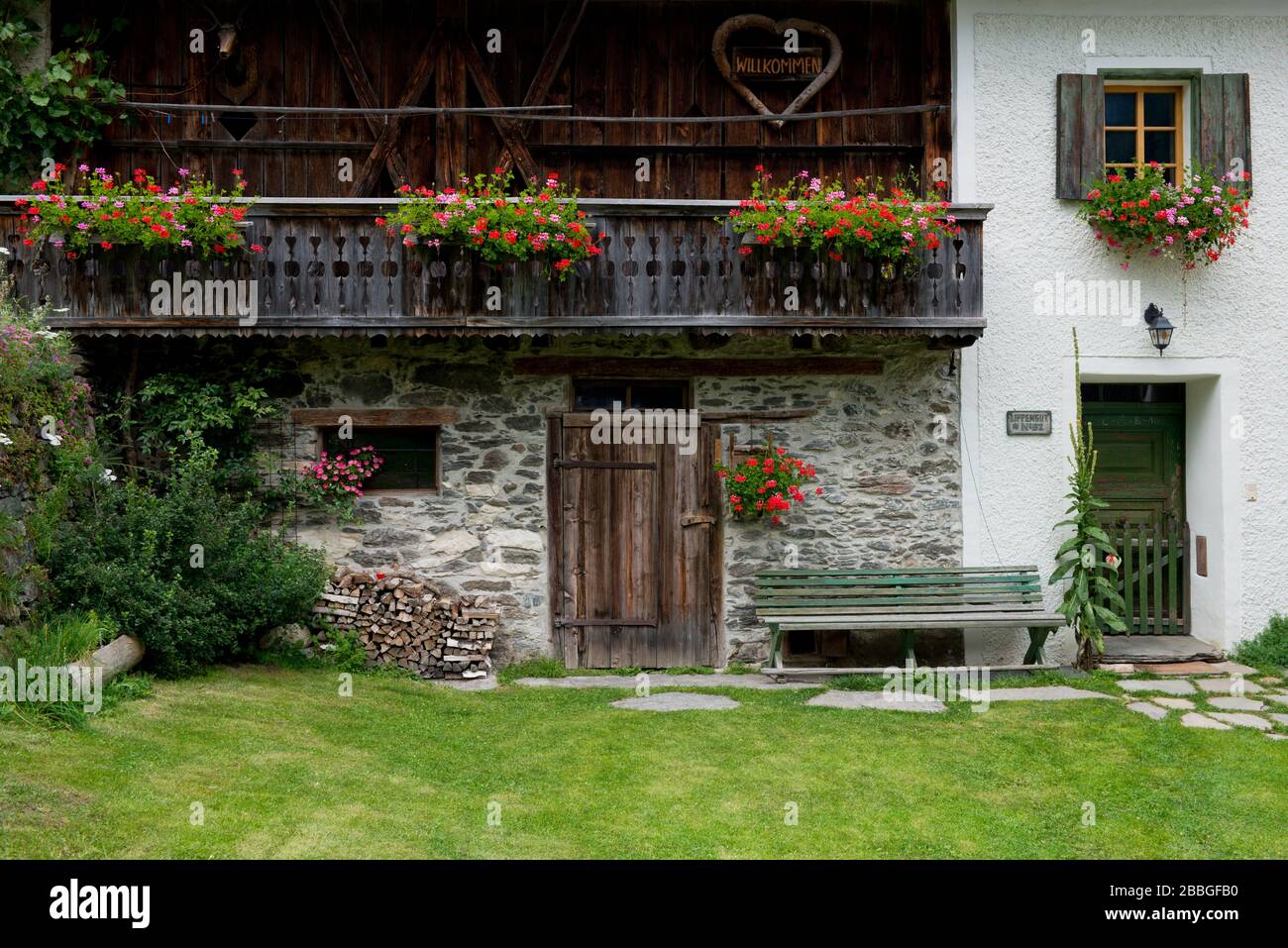 wooden balcony with green door, geranium pots in traditional alpine ...