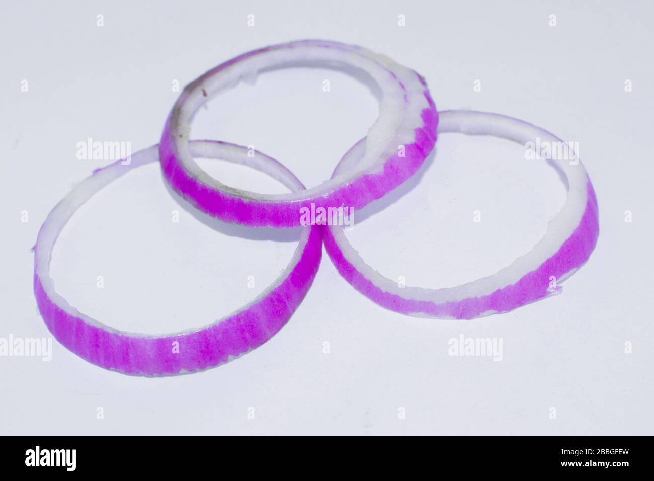 Three pink colored onion rings arranged as a pyramid in an isolated ...