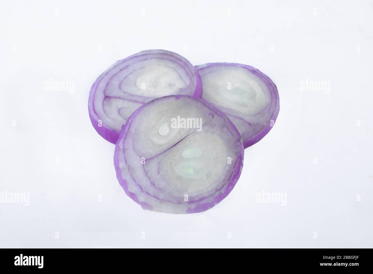 Three thick pink colored onion rings arranged as a pyramid in an ...