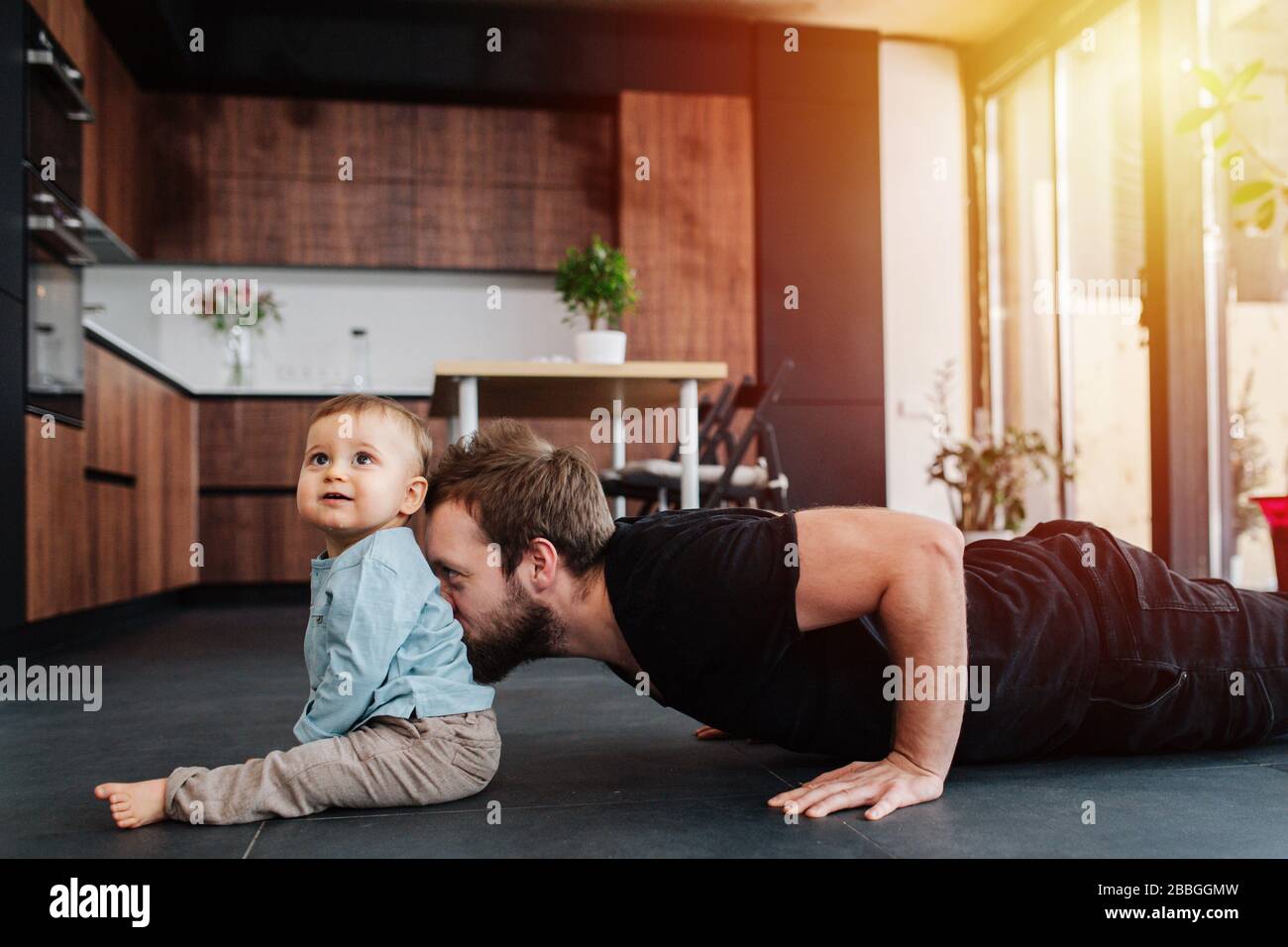 Happy father doing push upps next to his infant baby. Kissing his baby ...