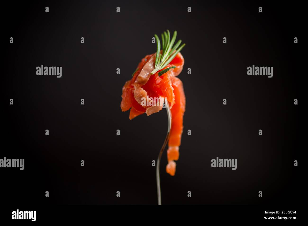 slice of salty red fish on a fork, black background Stock Photo - Alamy