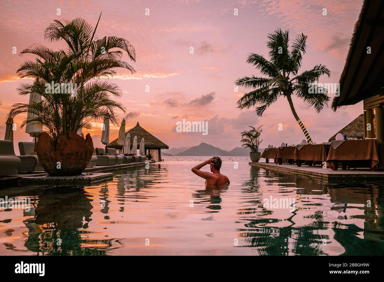 young men in swimming pool during sunset, Luxury swimming pool in ...