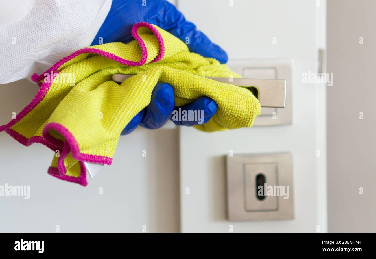 Hand in protective glove with rag cleaning door handle. Covid-19 ...