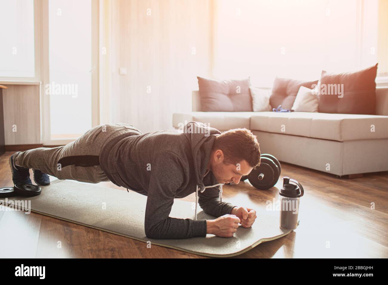 Young ordinary man go in for sport at home. Full size pictrue of ...