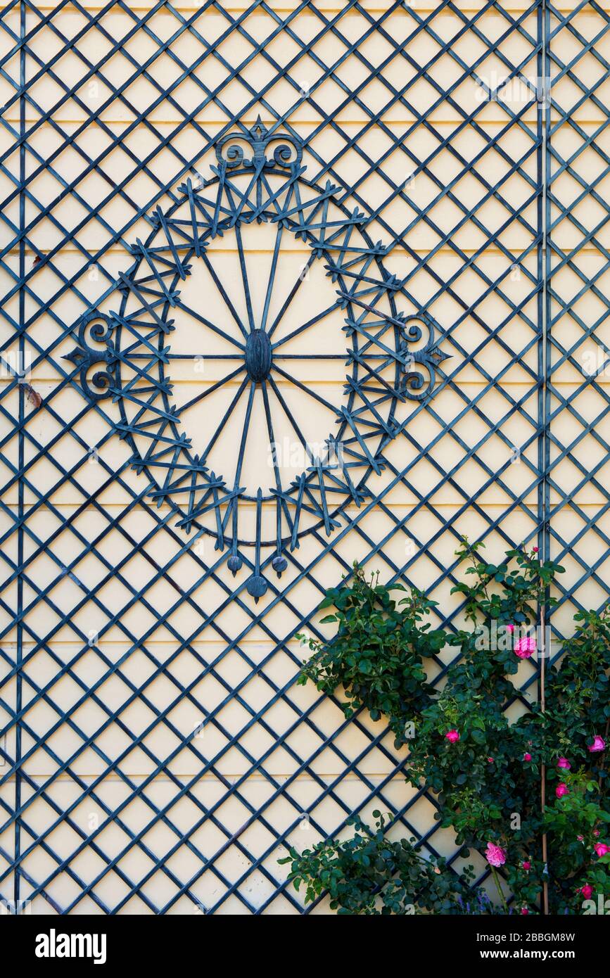 wooden trellis on yellow facade of Biedermeier castle with windows and ...