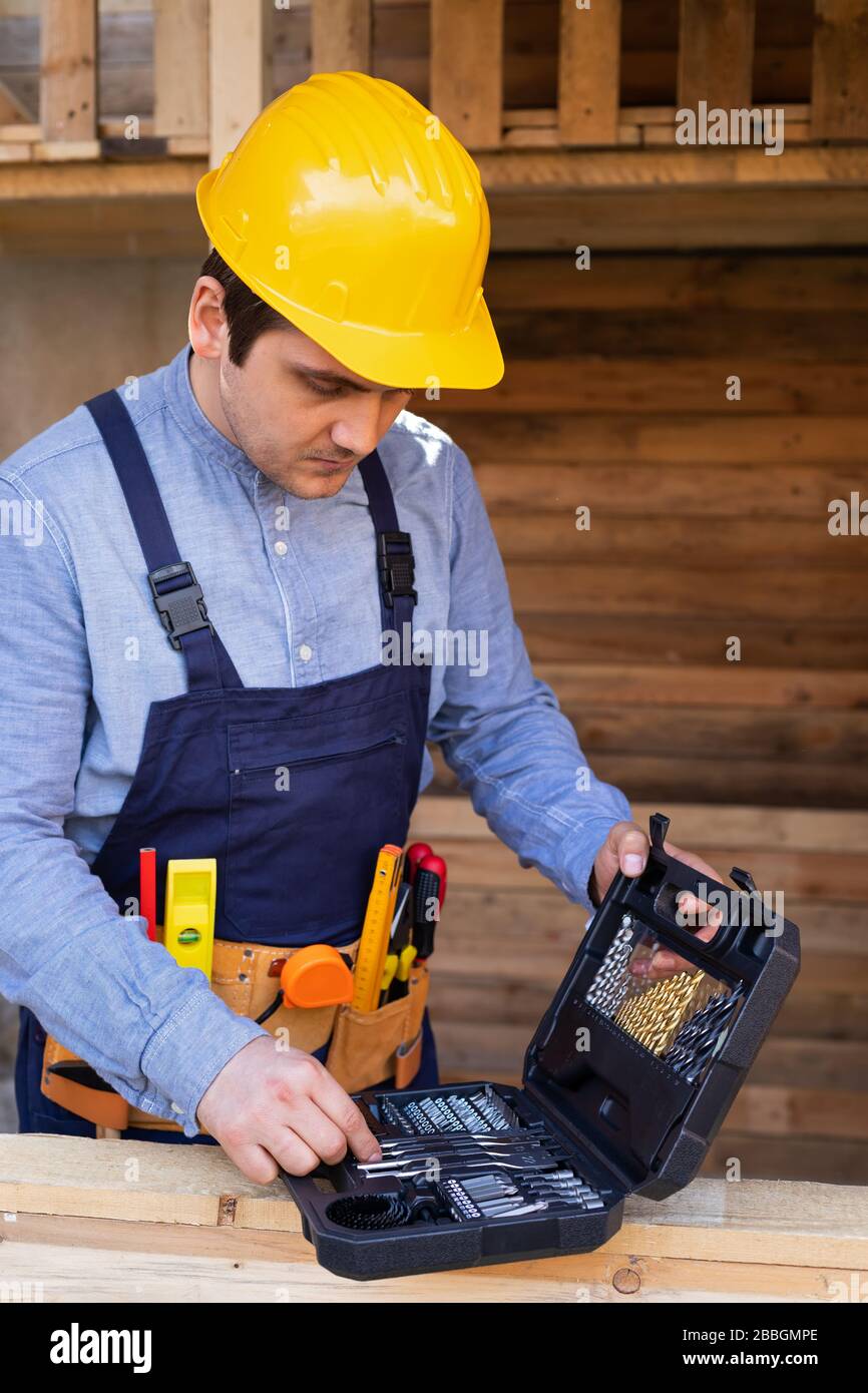 Repairman with yellow hard hat and work uniform holding tools for ...