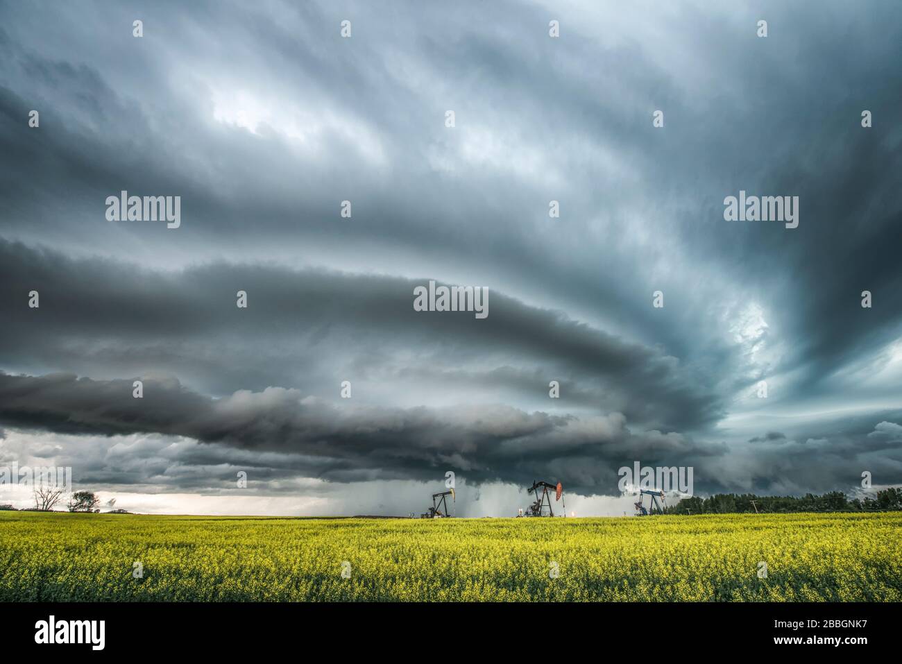 Storm with mesocyclone over a canola field with oil pumps in southern ...