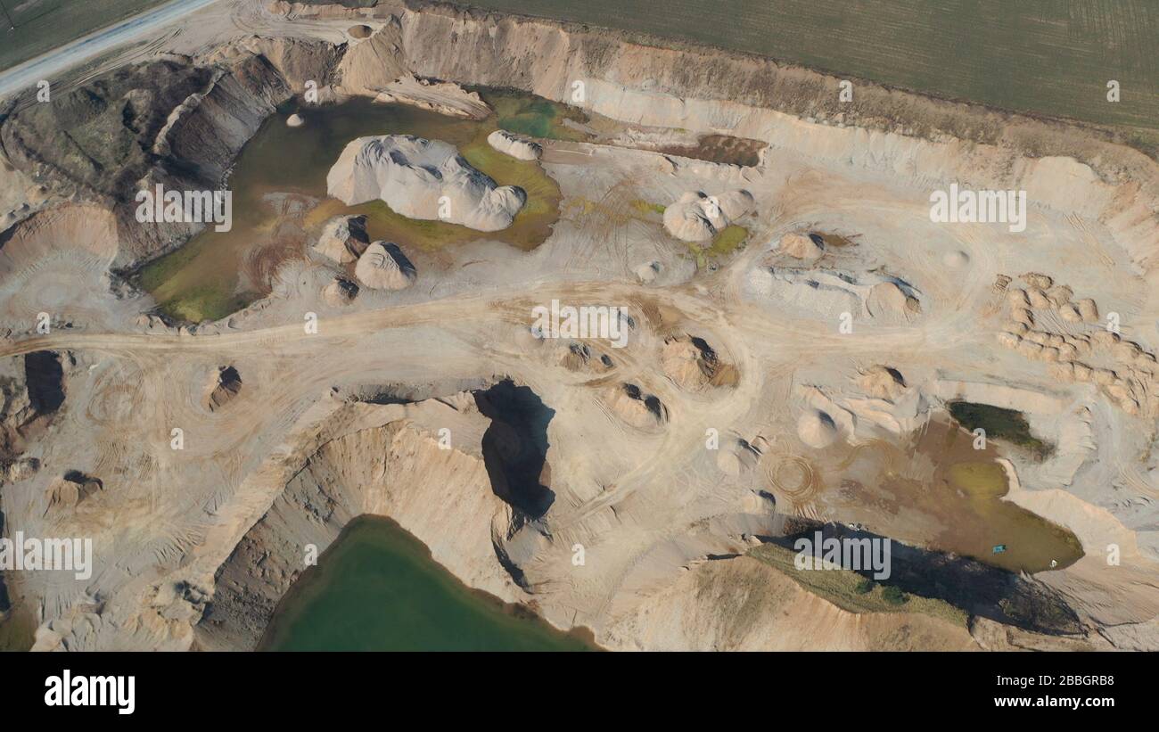 Aerial view of a opencast sand, gravel mine quarry full with green ...