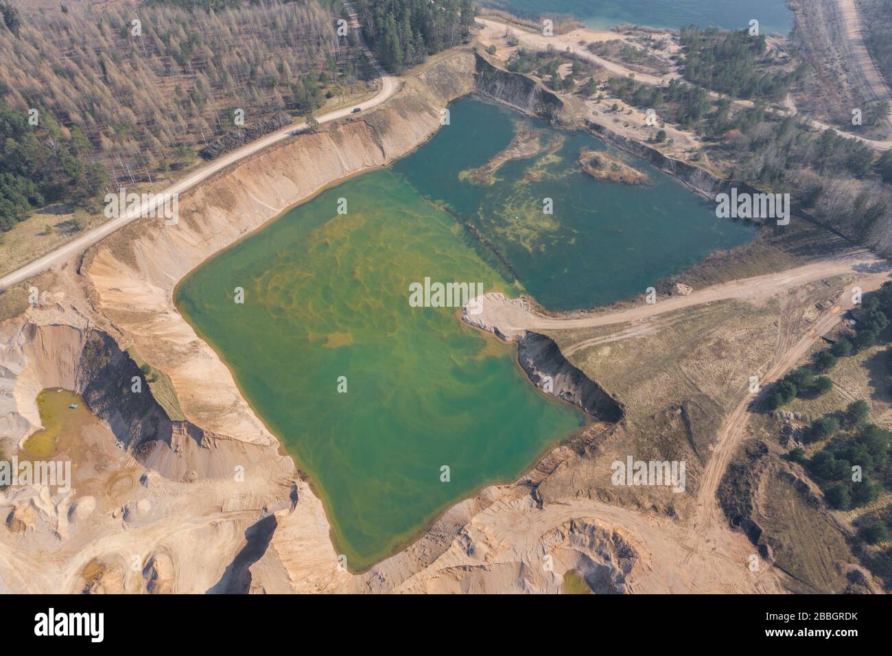Aerial view of a opencast sand, gravel mine quarry full with green ...