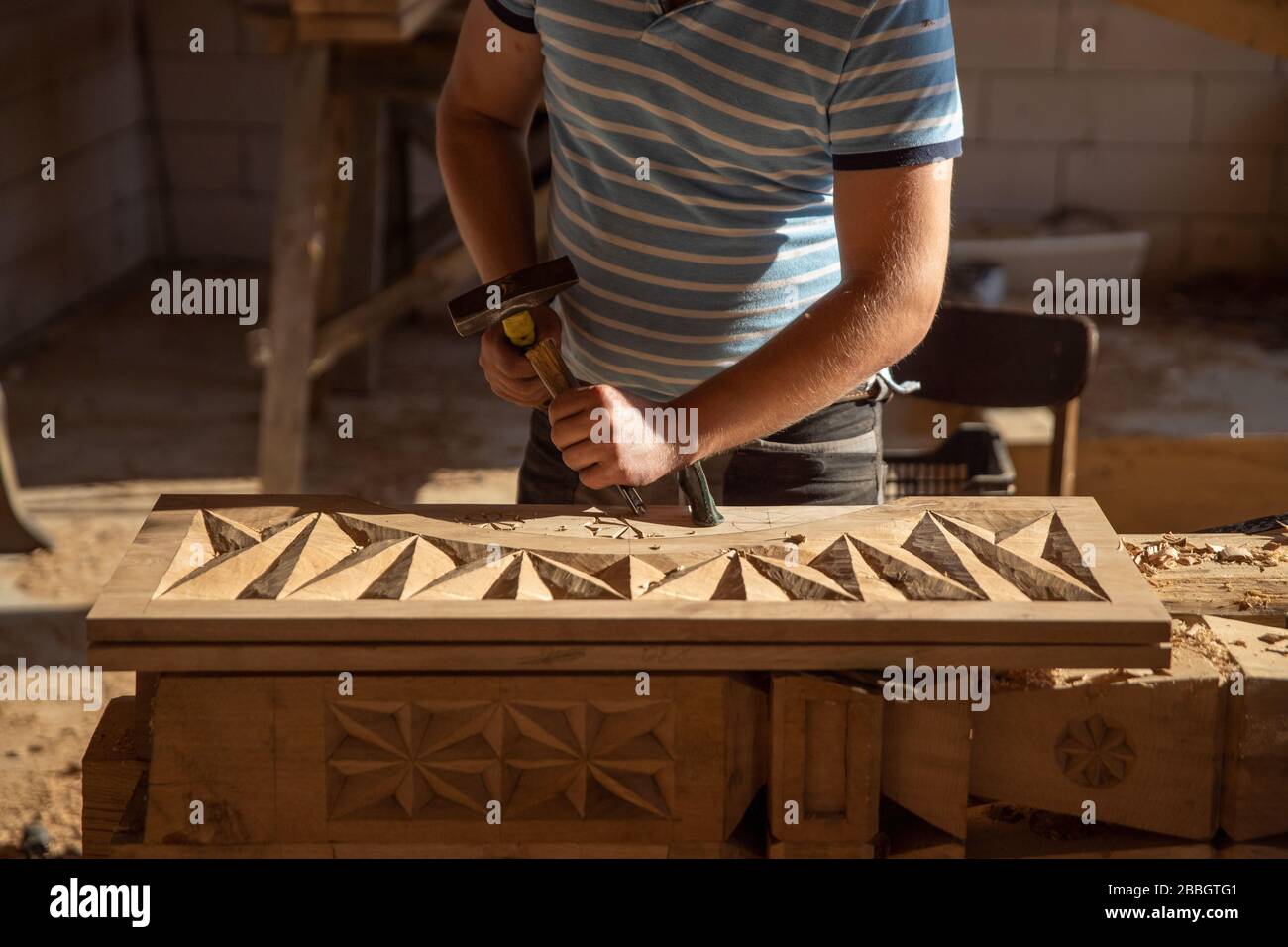 man carving traditional motifs from Maramures Romania in wood in the ...