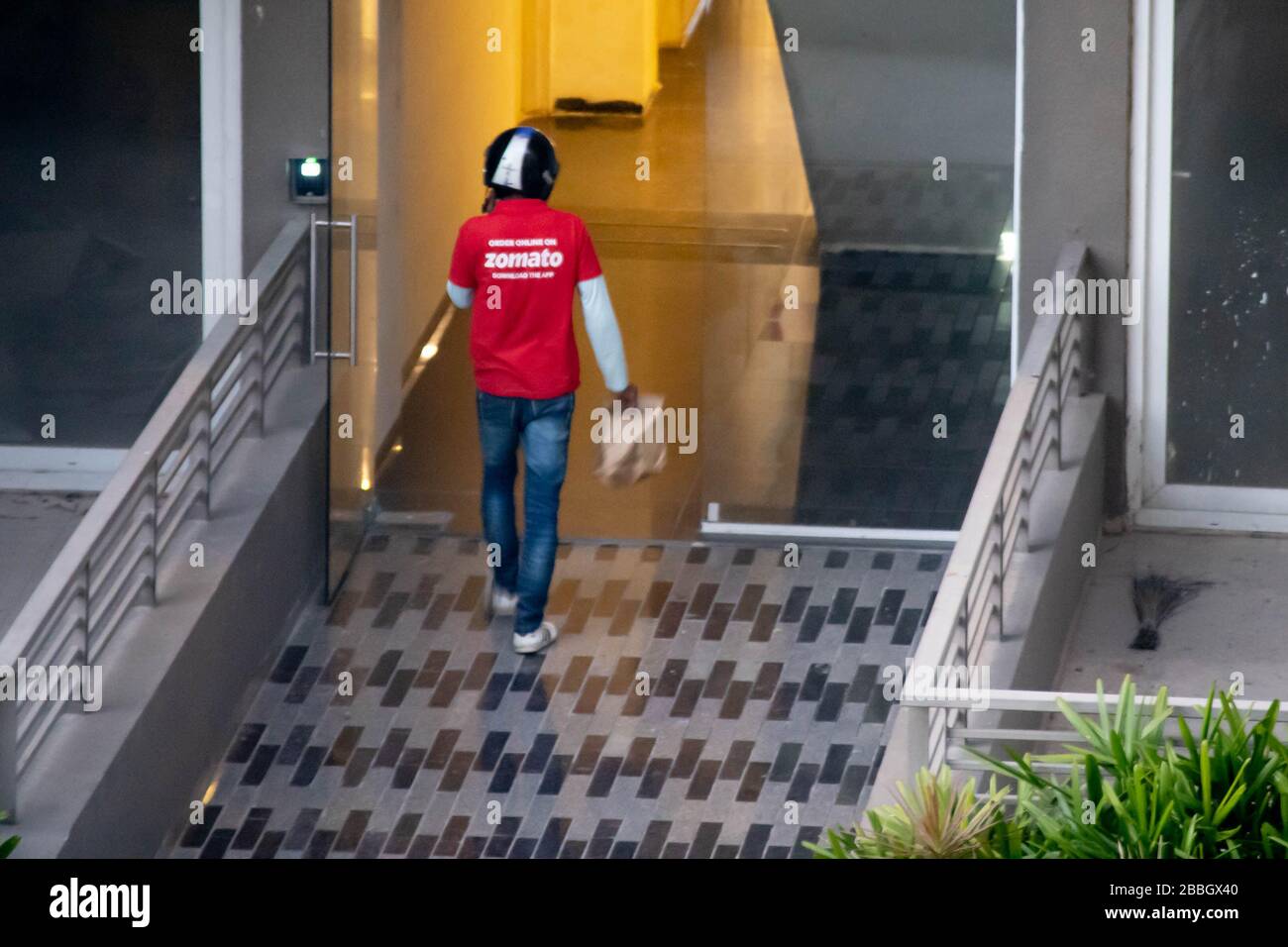 Zomato delivery person wearing the red shirt and carrying a bag for ...