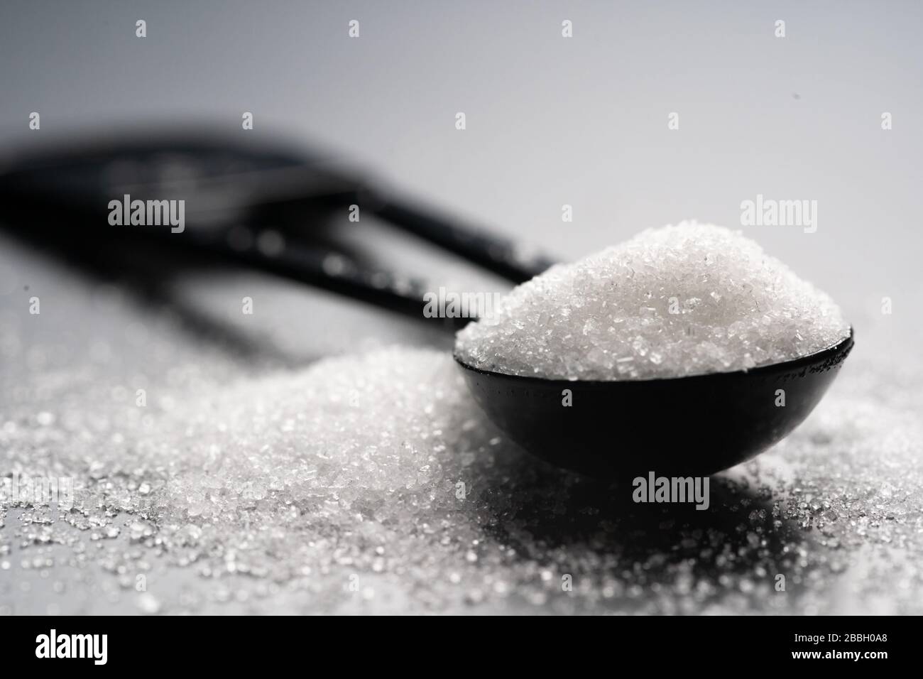 A set of black measuring spoon with salt on black background Stock ...