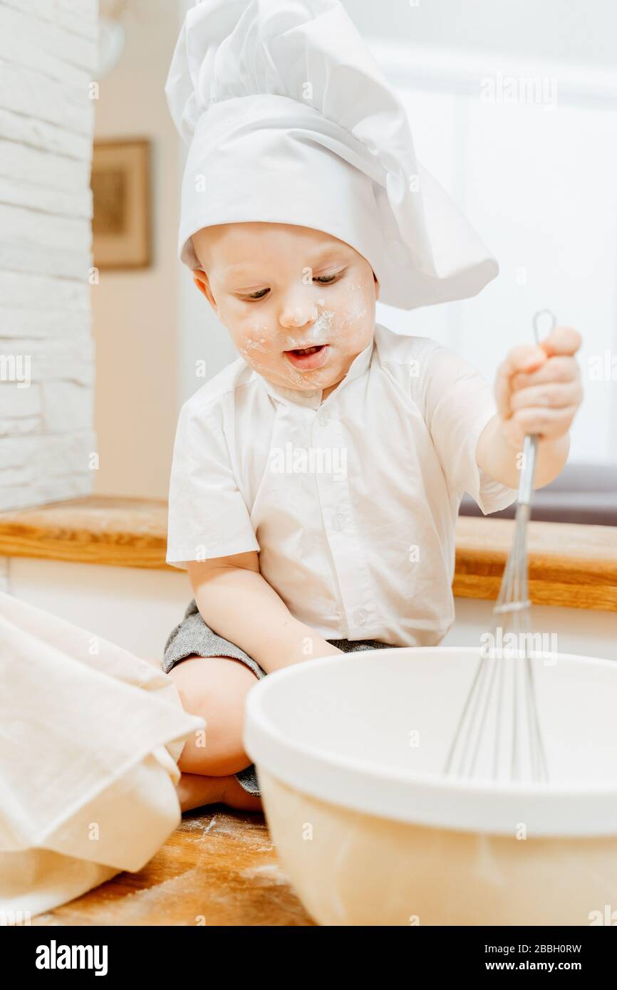 Boy in cook suit holding whisk with pancake Stock Photo - Alamy