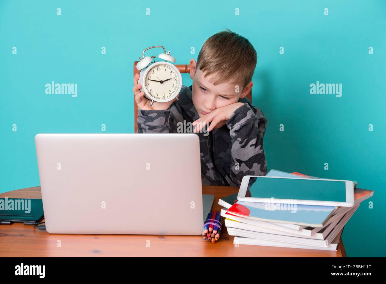 School kid using laptop while doing schoolwork at home. Homeschooling ...
