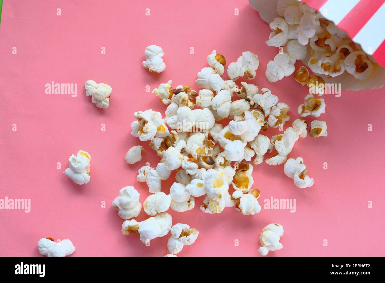 top view of popcorn spilling on pink background Stock Photo - Alamy