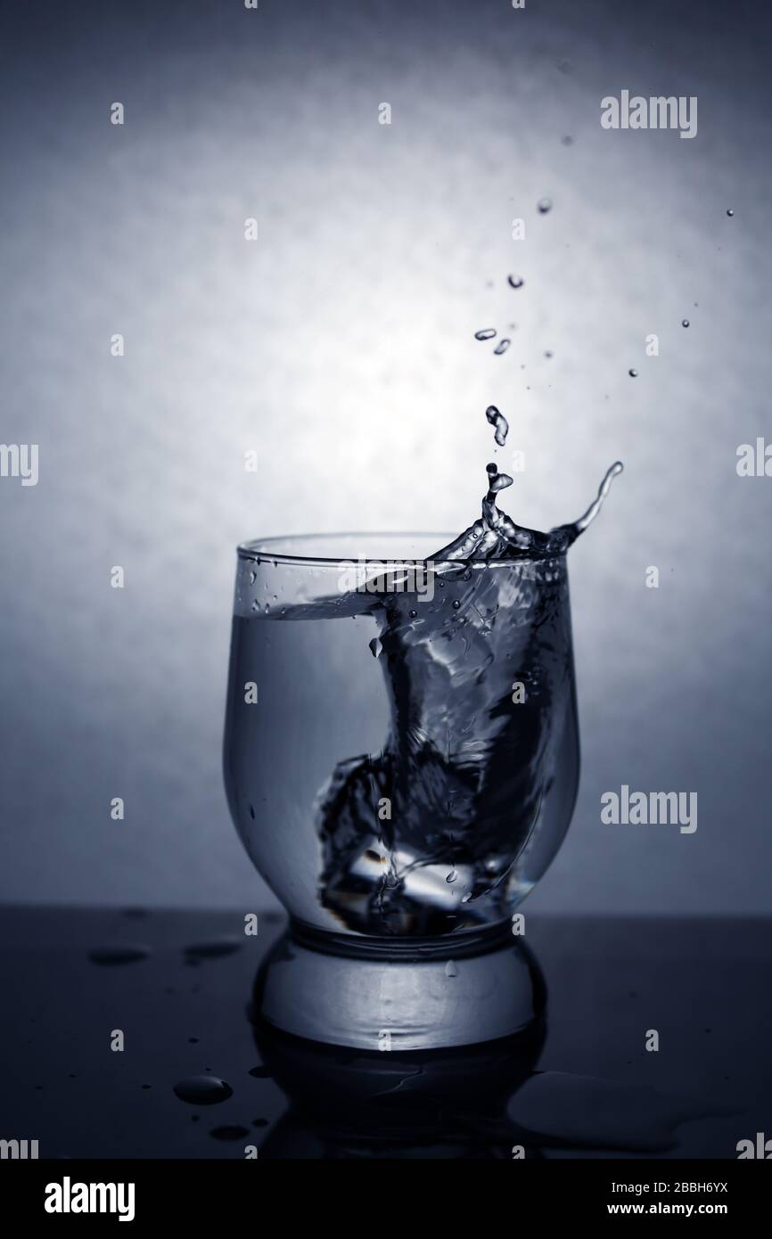 splashing from a glass when throwing ice cubes, vignetting Stock Photo ...