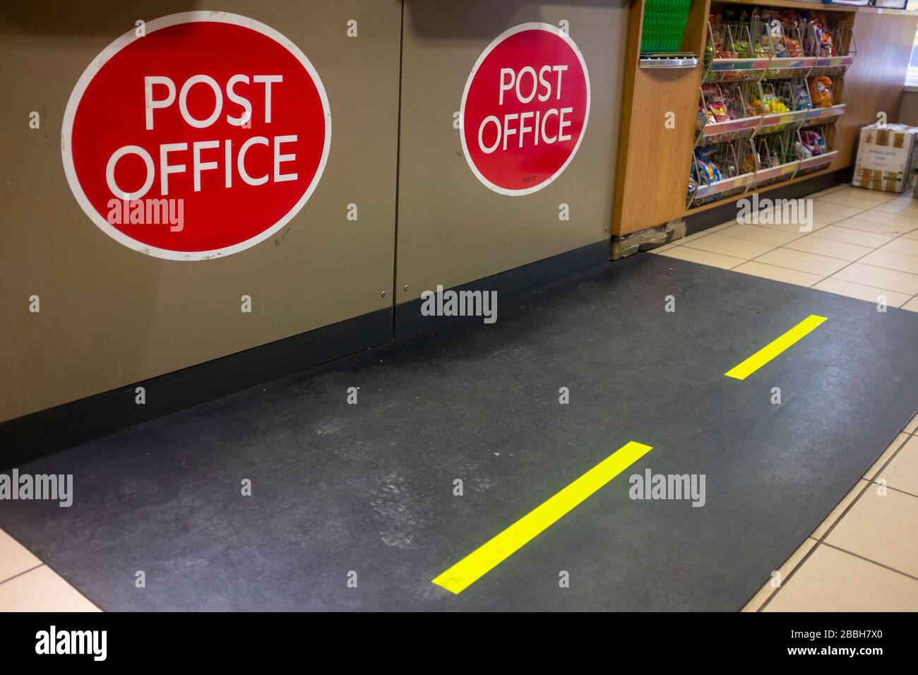 Durham, UK. 30th March 2020. A village post office enforces social ...