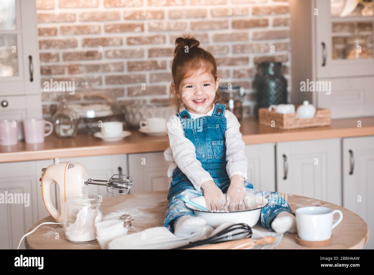 Funny baby girl 3-4 year old making pastry cake with flour and mixer ...