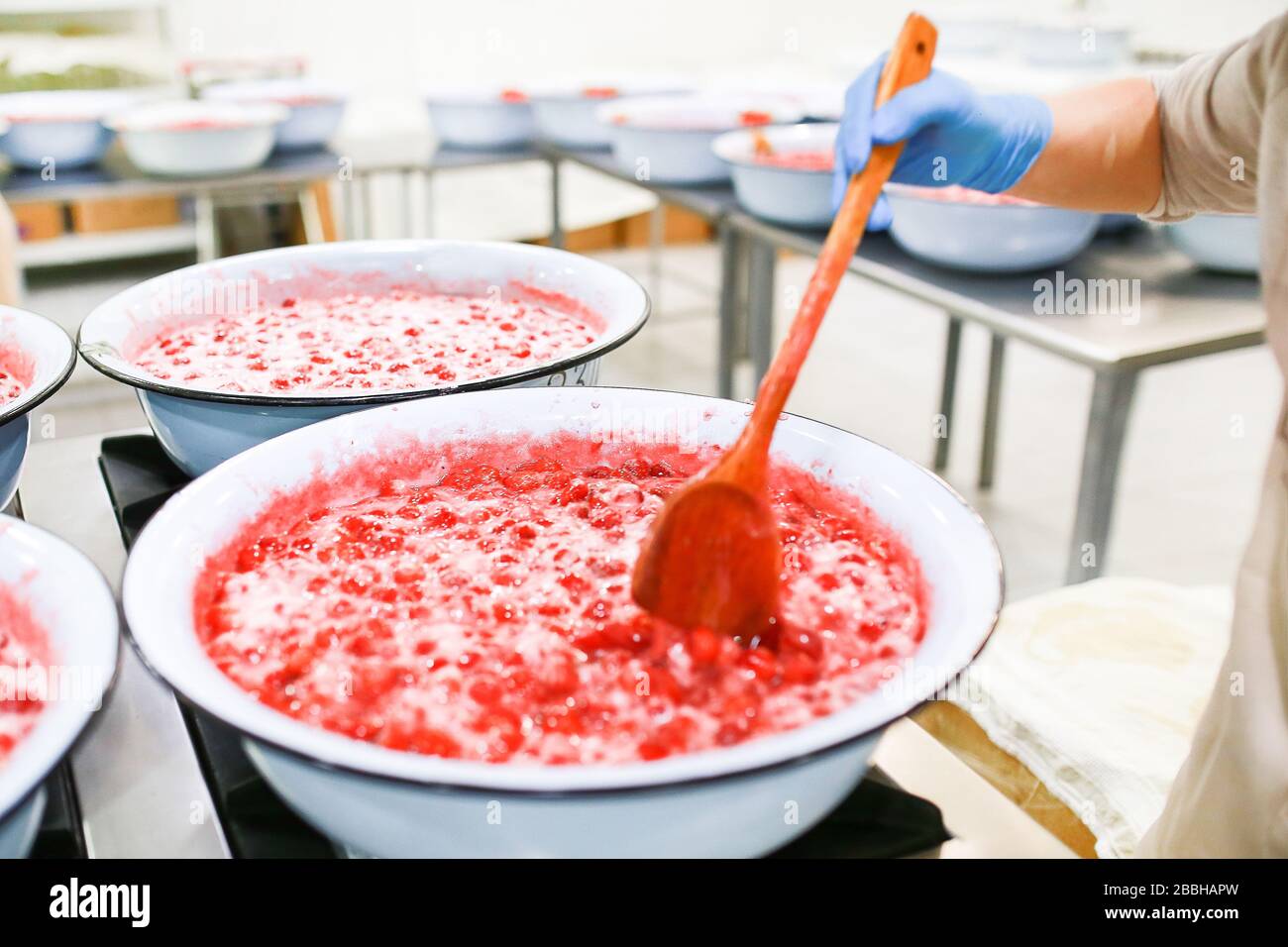 Strawberry jam cooking process. Wooden spoonmixing jam. Organic ...