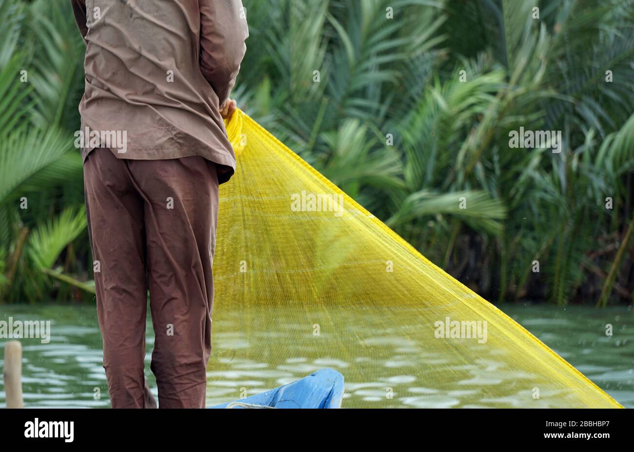 vietnamese fisherman on small boat fishing with fishnet Stock Photo - Alamy