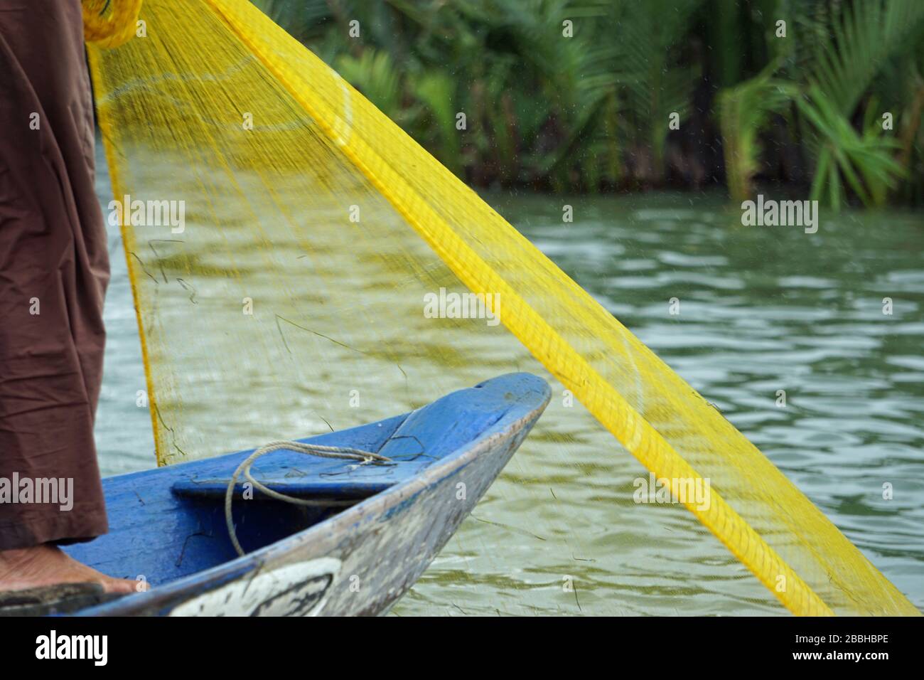 vietnamese fisherman on small boat fishing with fishnet Stock Photo - Alamy