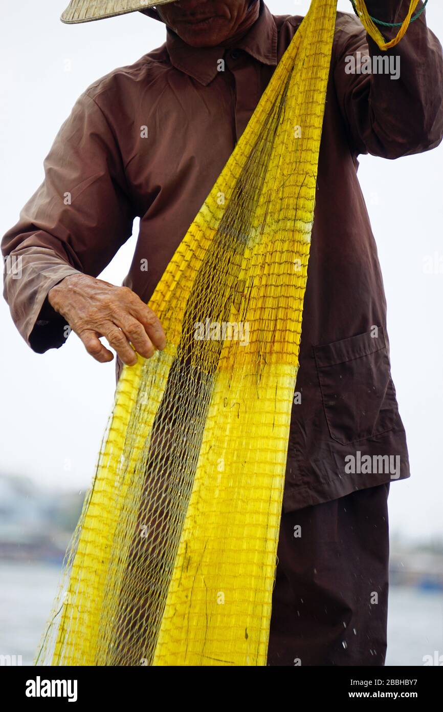 vietnamese fisherman on small boat fishing with fishnet Stock Photo - Alamy