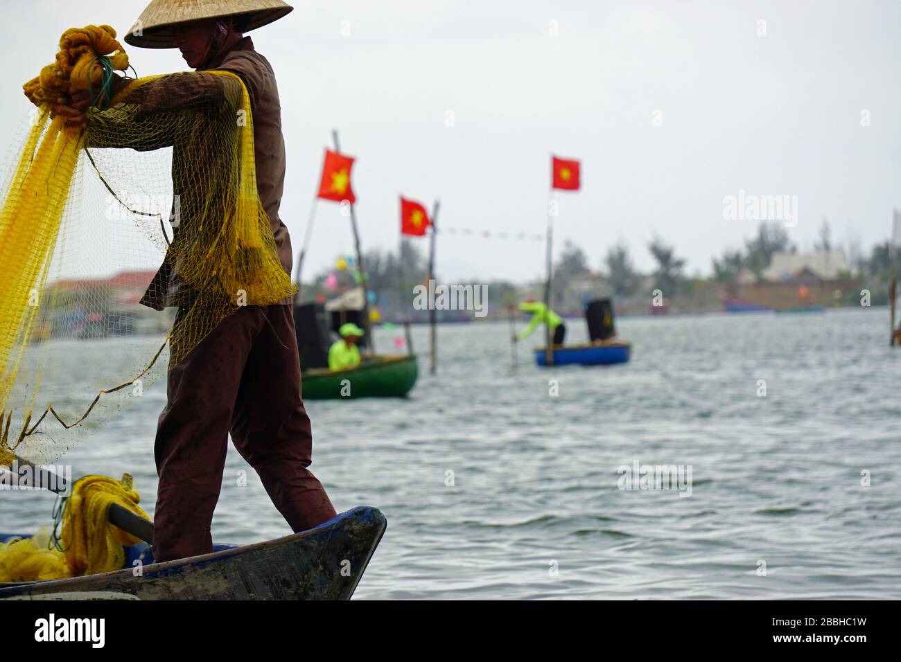 vietnamese fisherman on small boat fishing with fishnet Stock Photo - Alamy