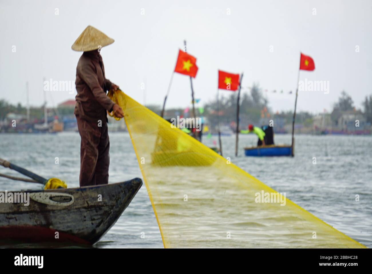vietnamese fisherman on small boat fishing with fishnet Stock Photo - Alamy