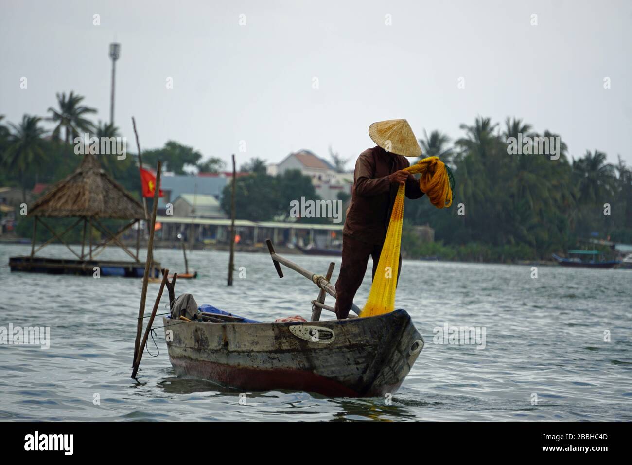 vietnamese fisherman on small boat fishing with fishnet Stock Photo - Alamy