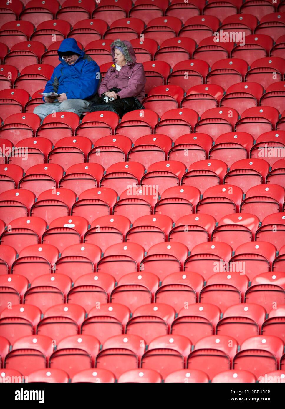 Two lonely fans sit amidst empty seats Stock Photo - Alamy