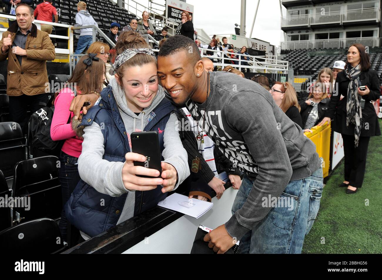 JLS singer Oritse poses for photographs with fans before the game Stock ...
