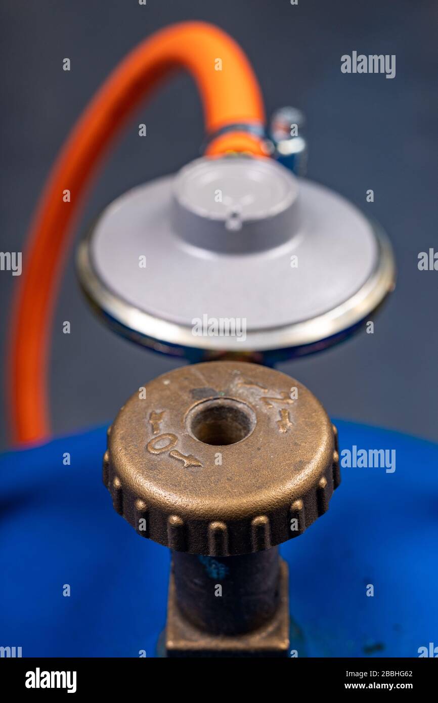 Gas cylinder, reducer. Gas installation accessories. Dark background ...
