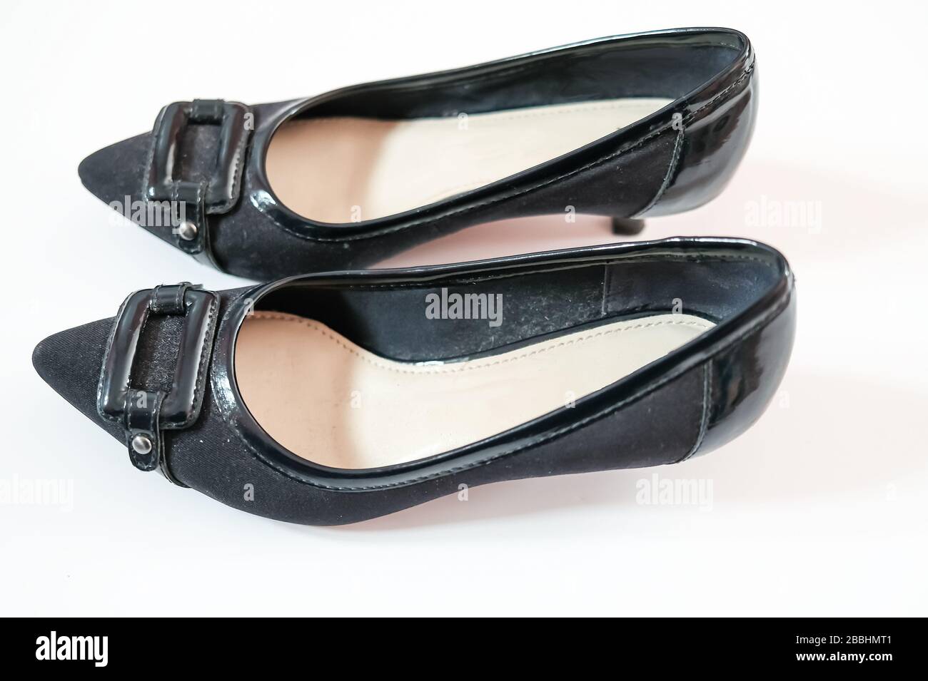 Side on view of a pair of ladies black heeled shoes with a square ...