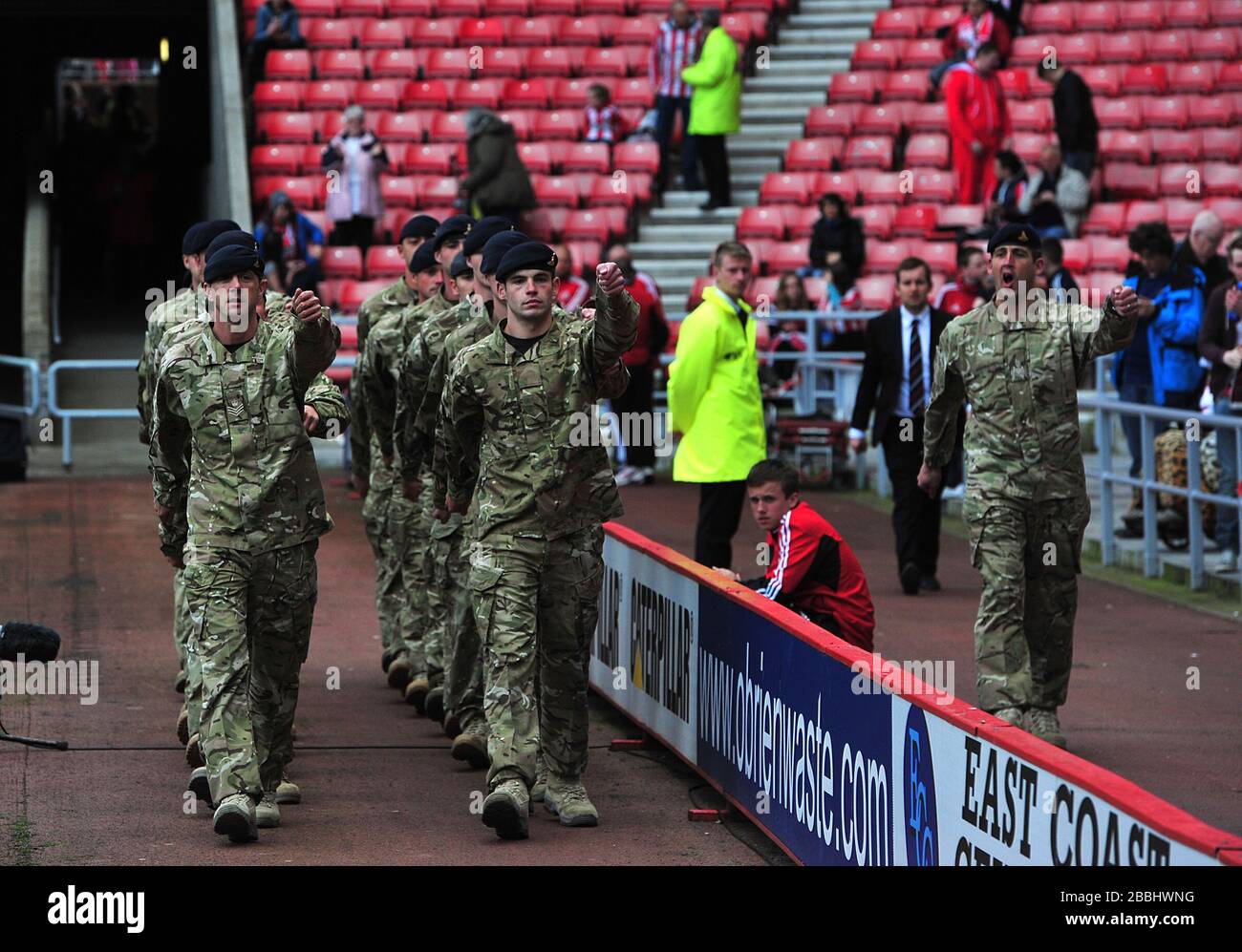 Members of the armed forces march around the pitch hi-res stock ...