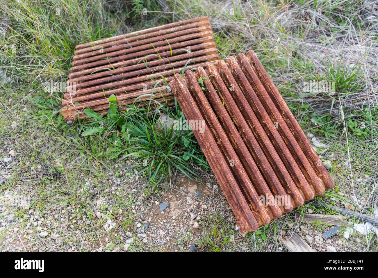 Rusty iron radiators lying on the ground on the green grass Stock Photo ...