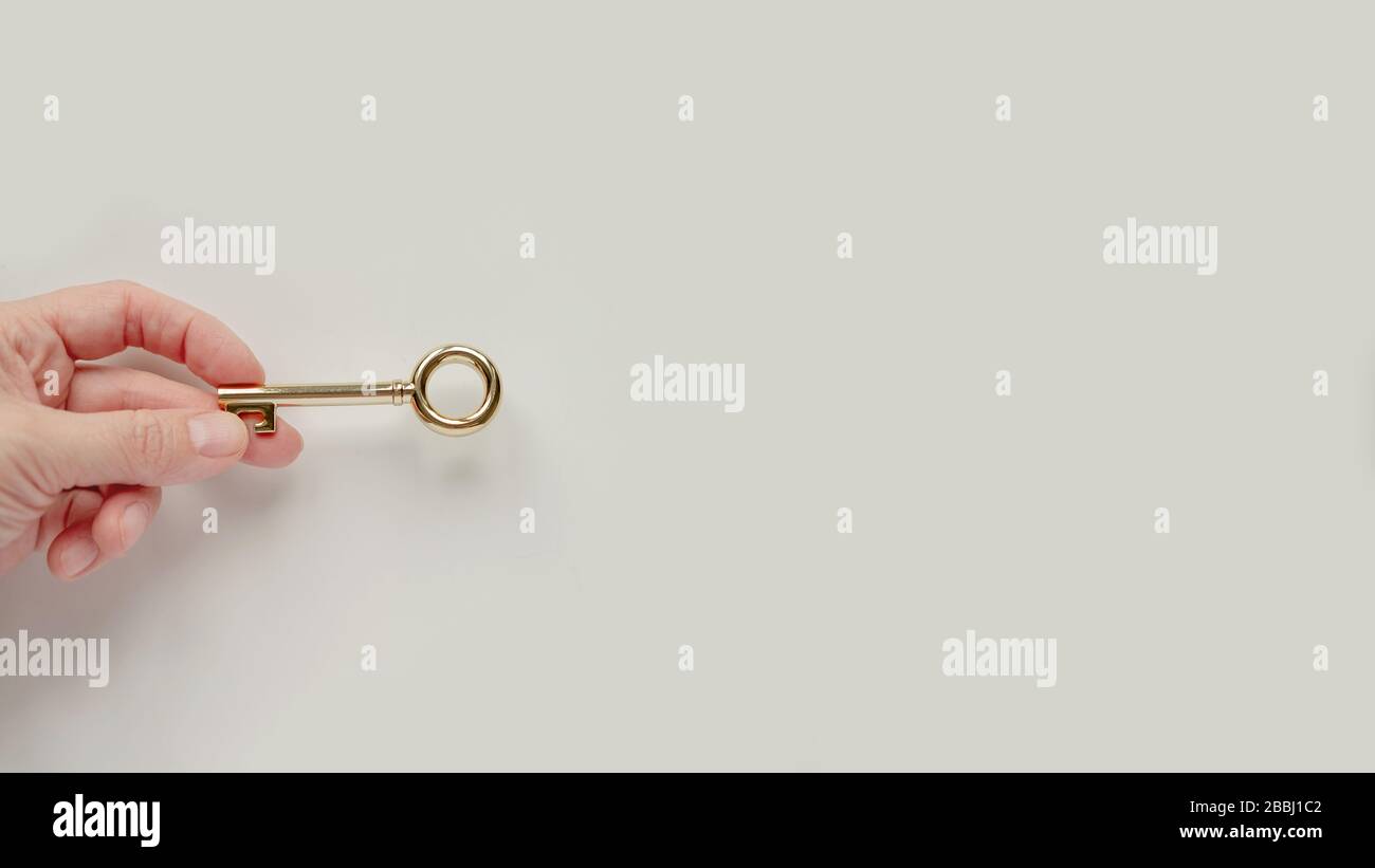 Gold key in woman hand on white background with copyspace. Stock photo ...