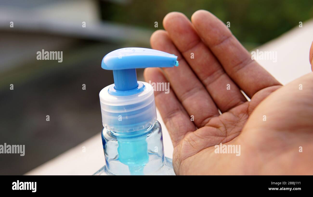 Washing hands with alcohol based gel from a hand pump bottle to protect ...