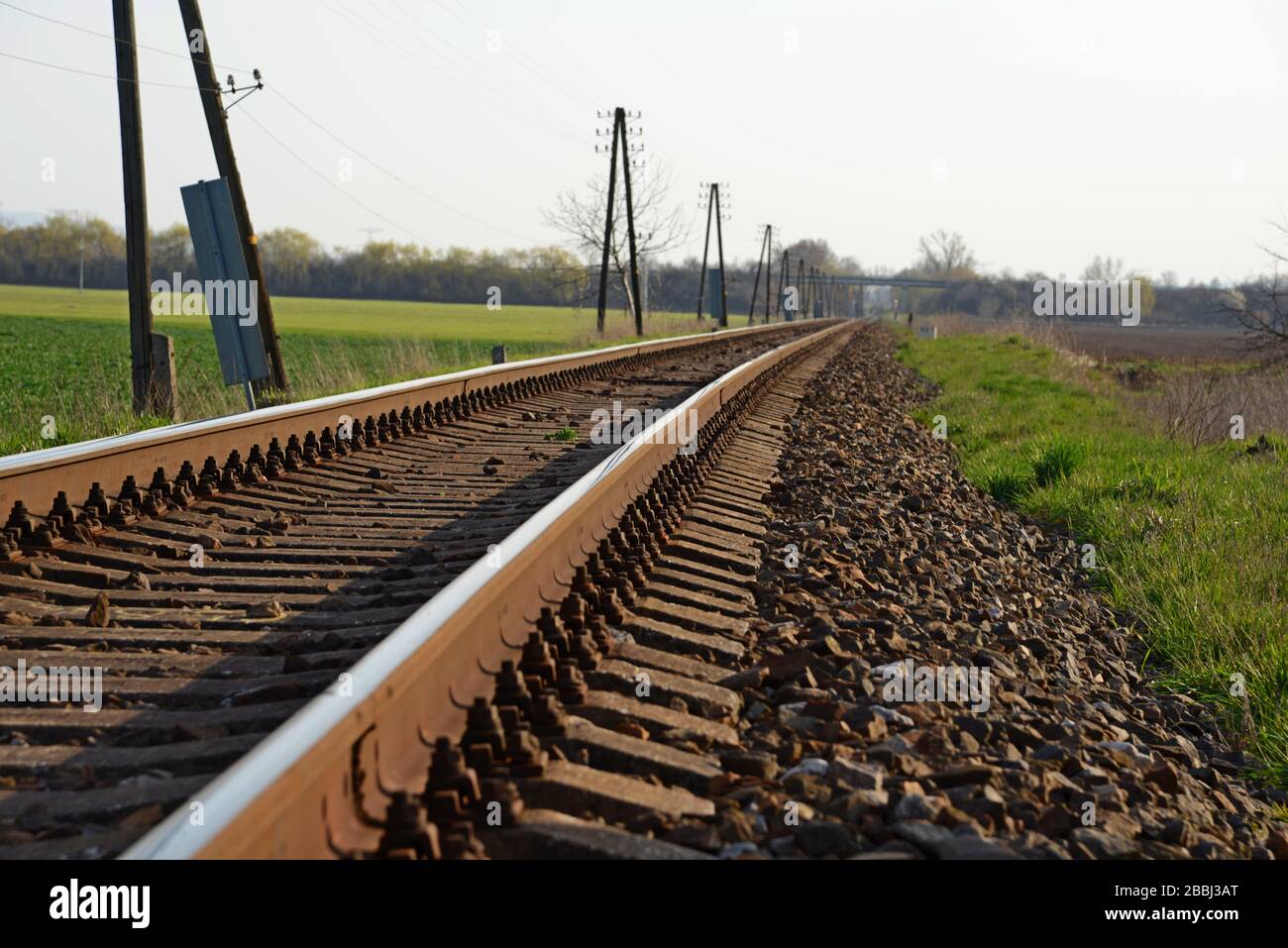 Railroad tracks with electric poles and sky Stock Photo - Alamy