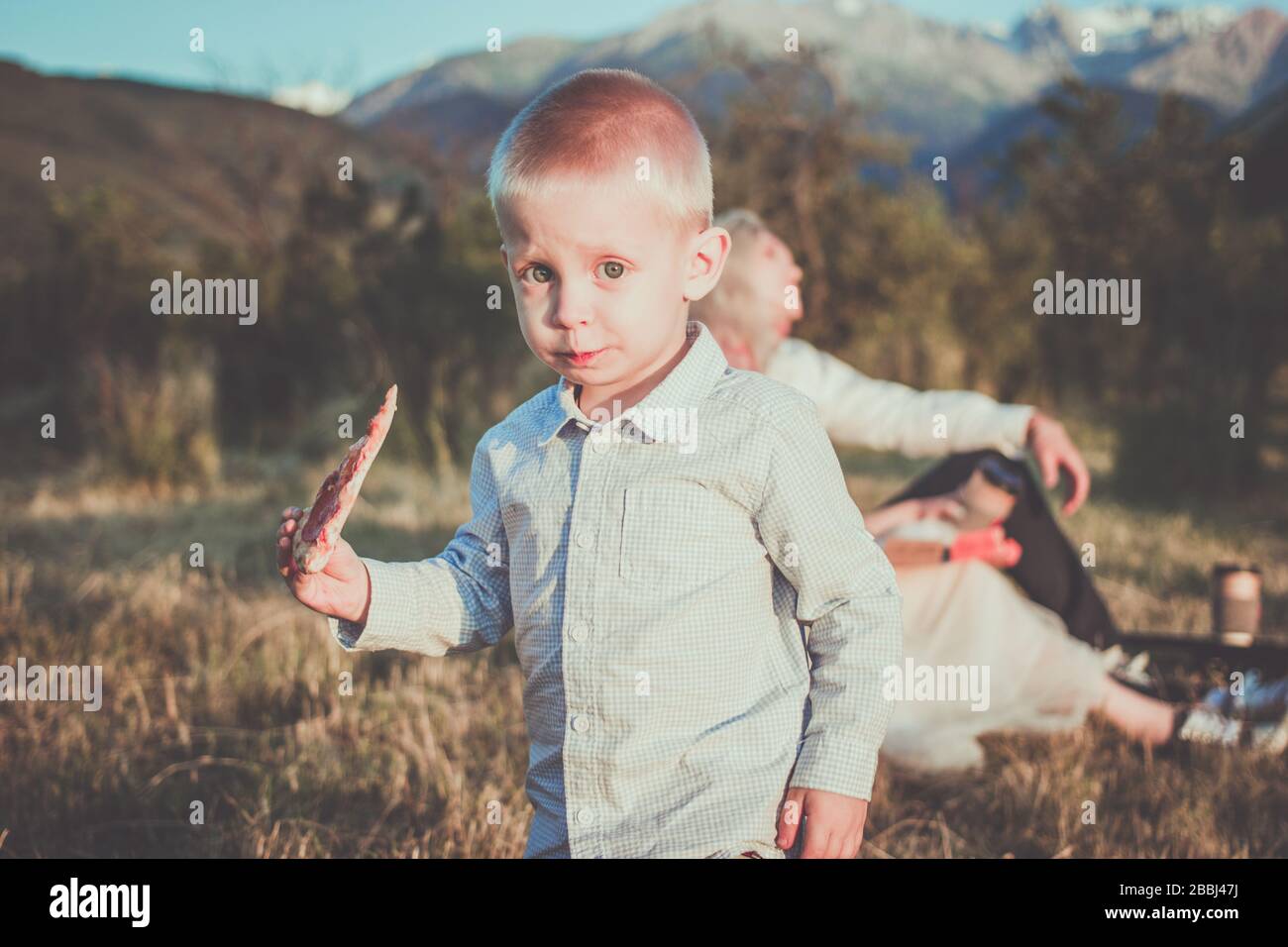 Cute little blonde haired toddler boy eating delicious slice of pizza ...